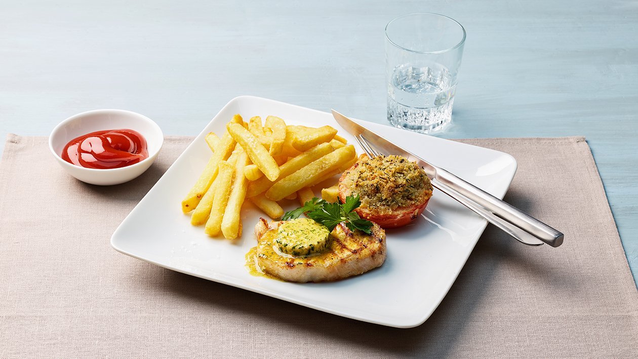 Steak de porc grillé, beurre aux herbes, pommes frites et tomate Provençale